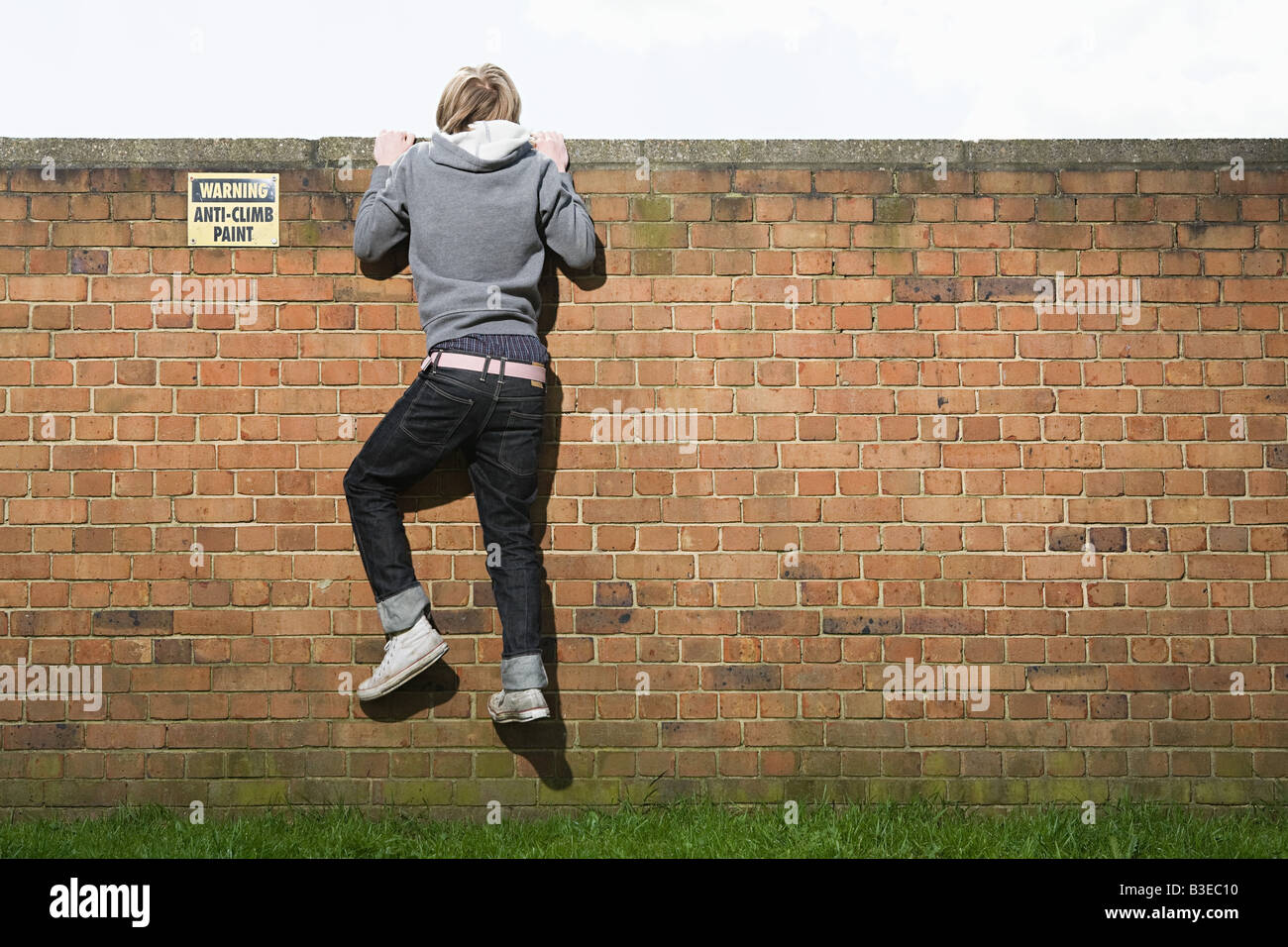 Teenage boy climbing wall Stock Photo - Alamy