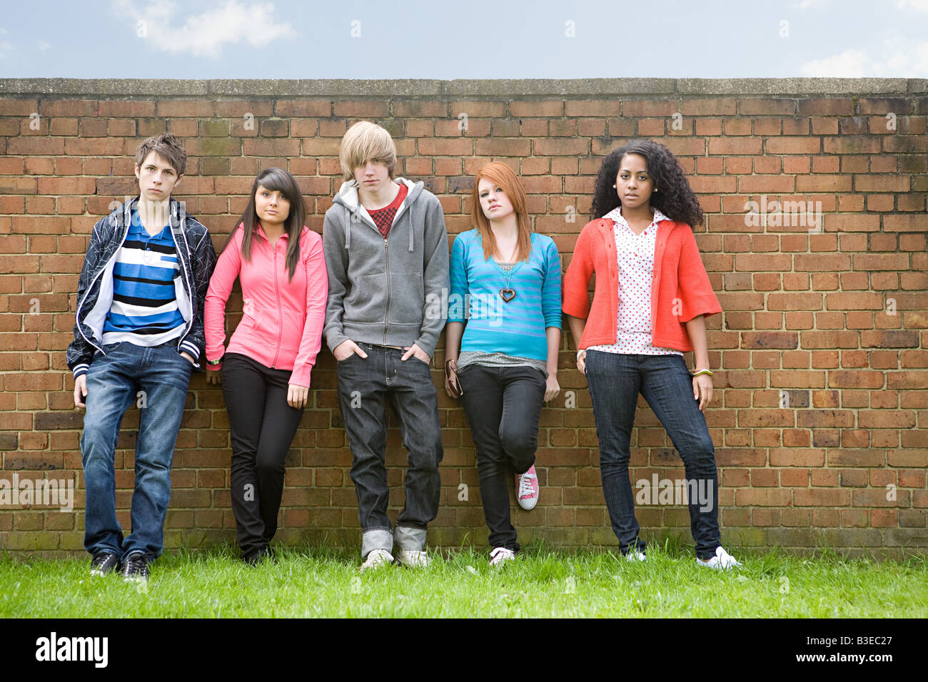 Teens standing by wall Stock Photo - Alamy