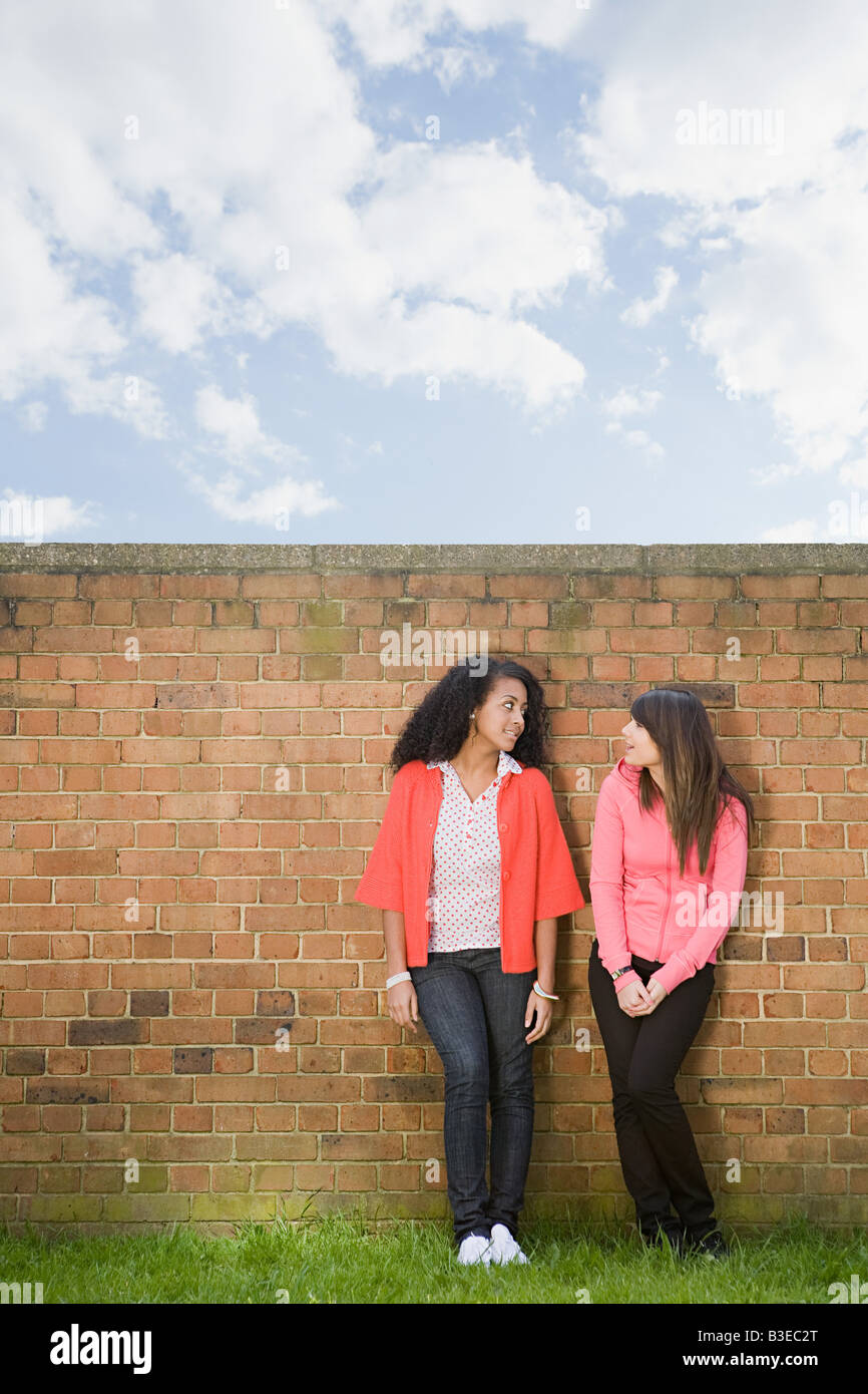 Two teenage girls by wall Stock Photo - Alamy