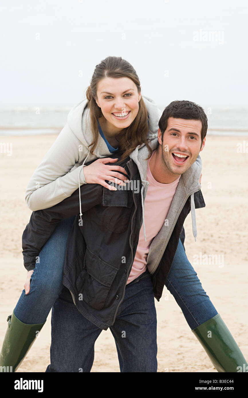 Man giving woman a piggyback Stock Photo - Alamy