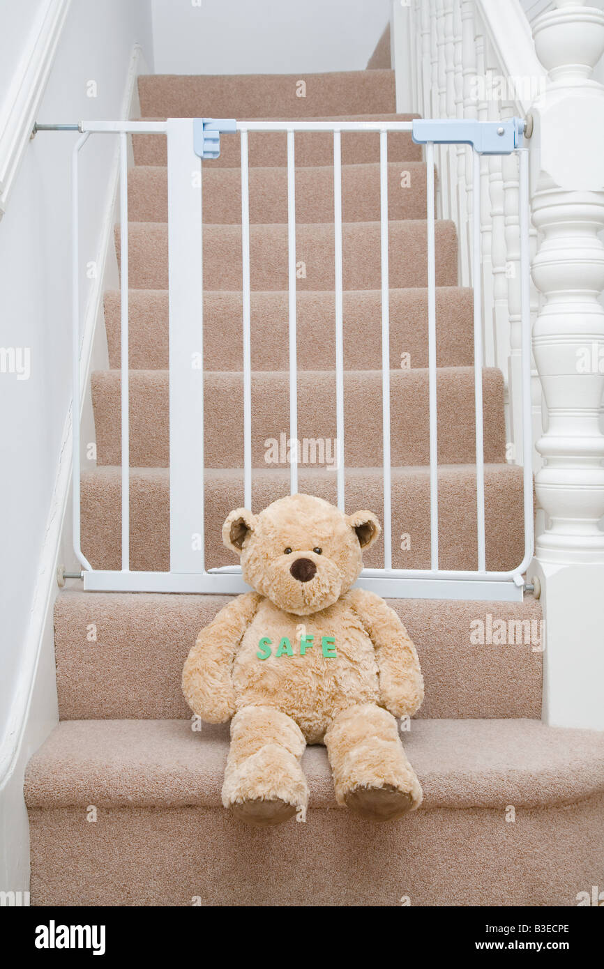 Teddy bear and stair gate Stock Photo - Alamy