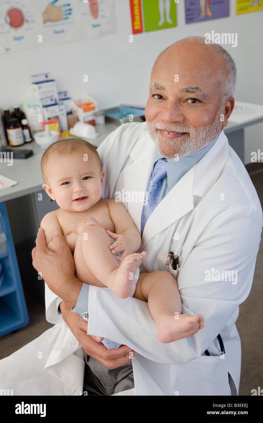 Portrait of a doctor holding a baby Stock Photo - Alamy