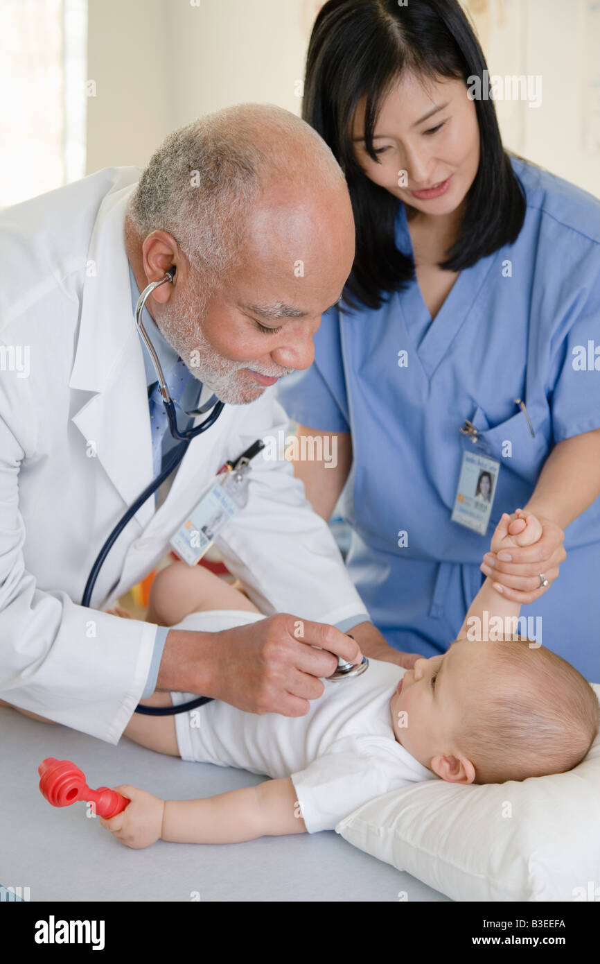 A doctor and nurse examining a baby Stock Photo - Alamy