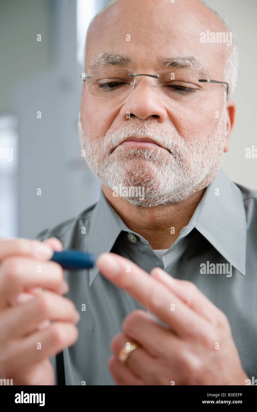 A man doing a home blood glucose testing Stock Photo - Alamy