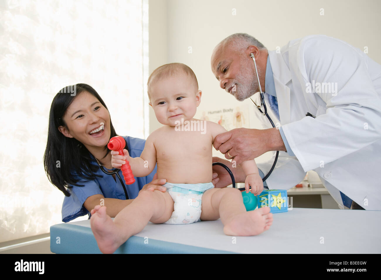 A doctor and nurse examining a baby Stock Photo - Alamy