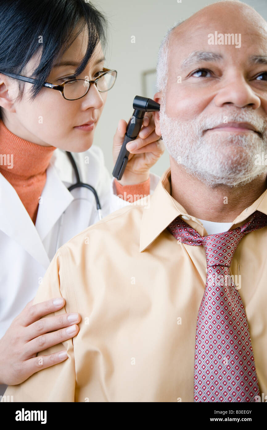 A doctor examining a patients ear Stock Photo - Alamy