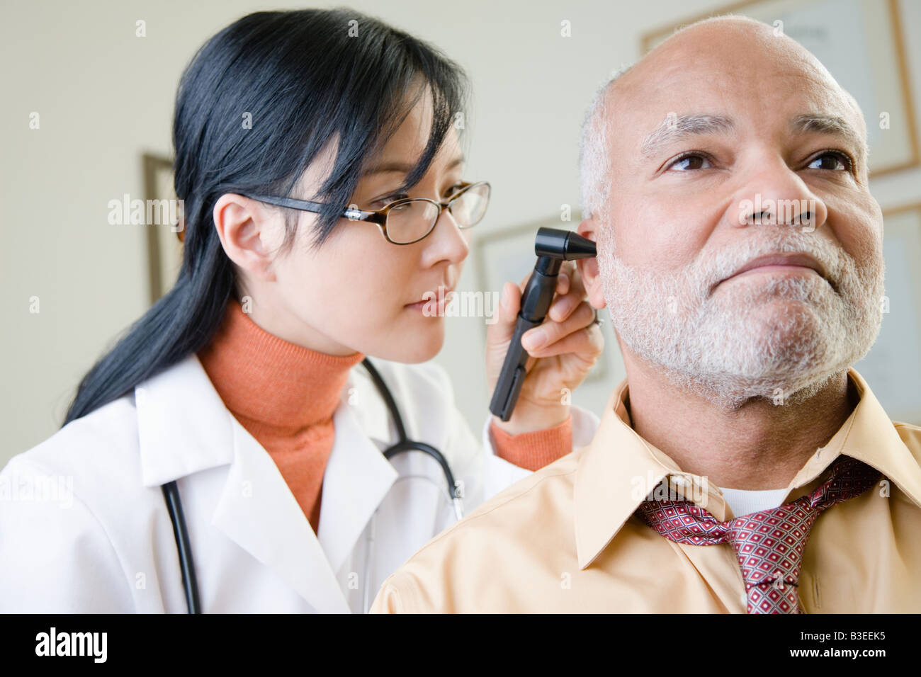 A doctor examining a patients ear Stock Photo - Alamy