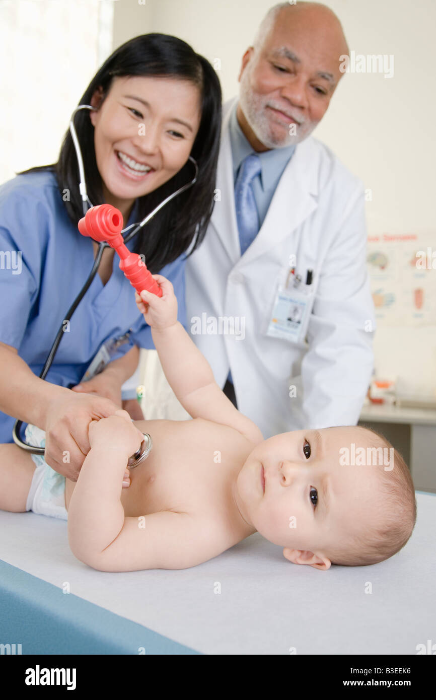 A doctor and nurse examining a baby Stock Photo - Alamy