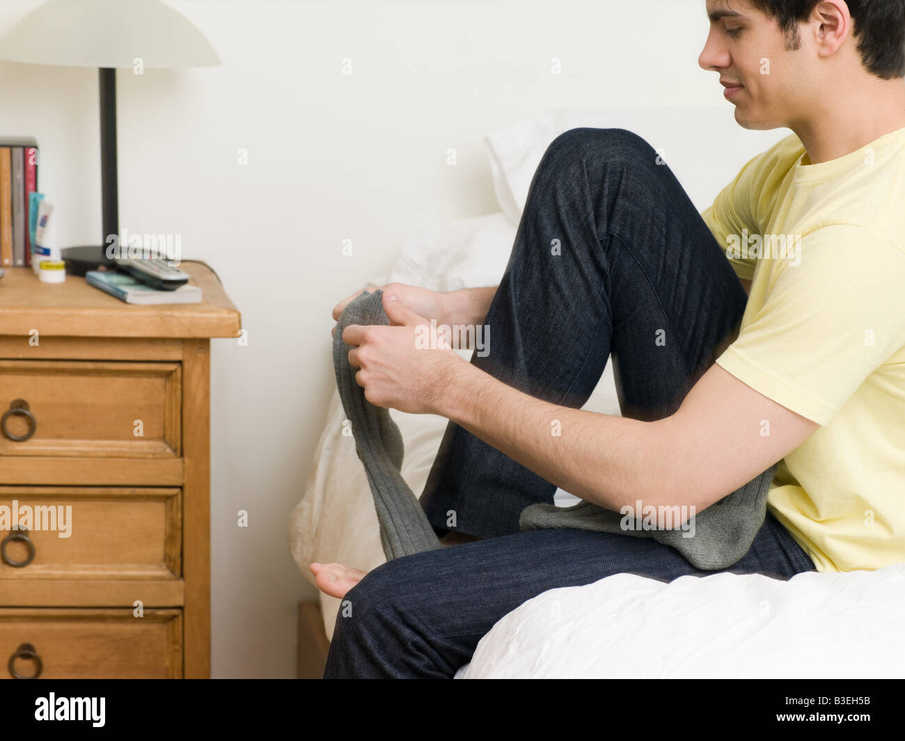 Man putting on socks Stock Photo - Alamy