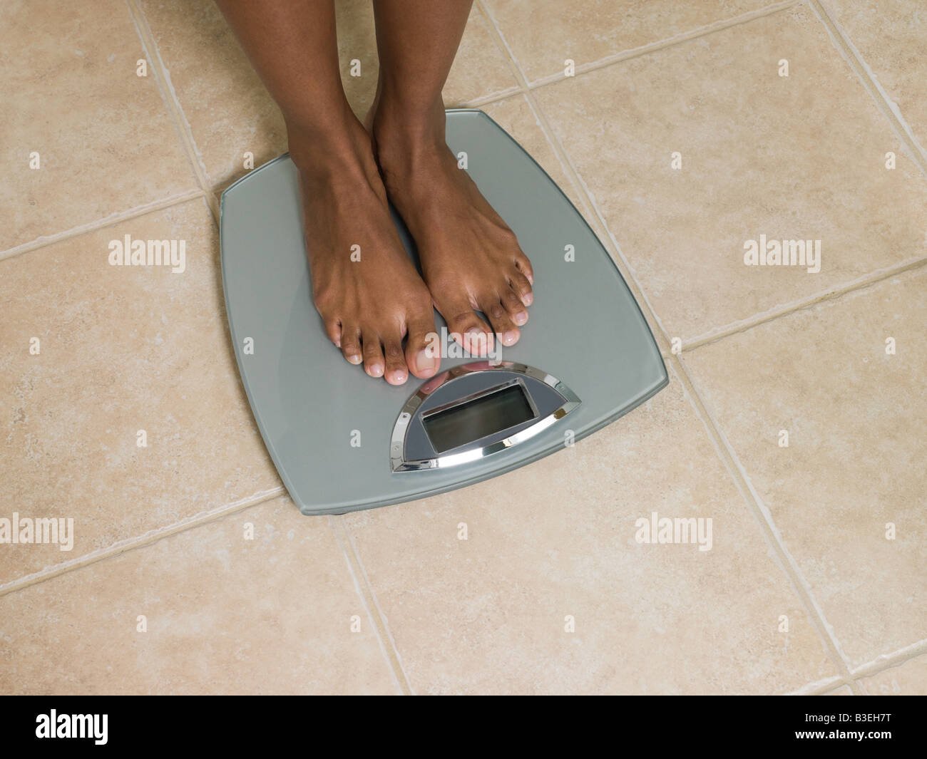 Feet of woman on scales Stock Photo - Alamy