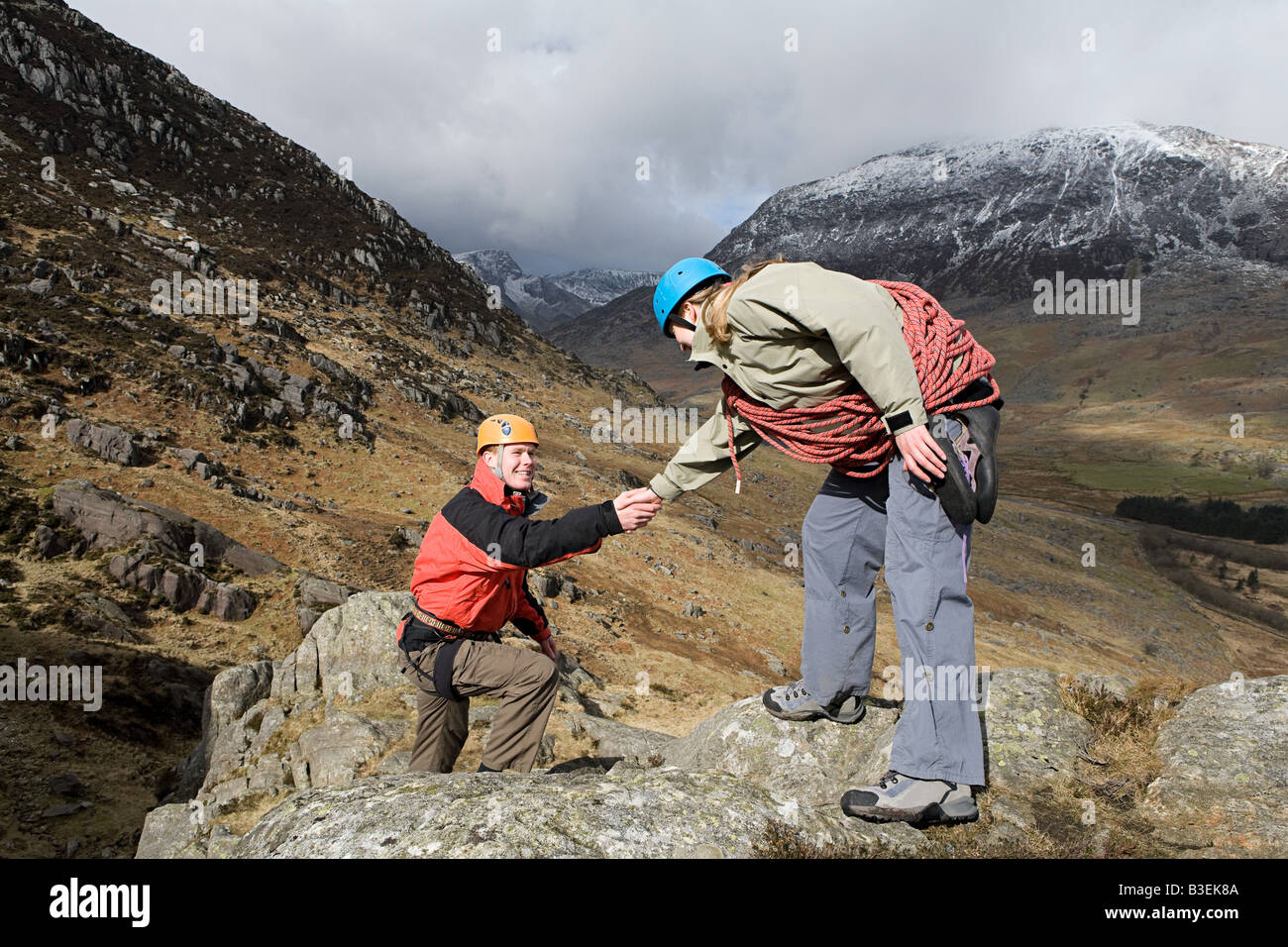 A woman giving a man a helping hand Stock Photo - Alamy