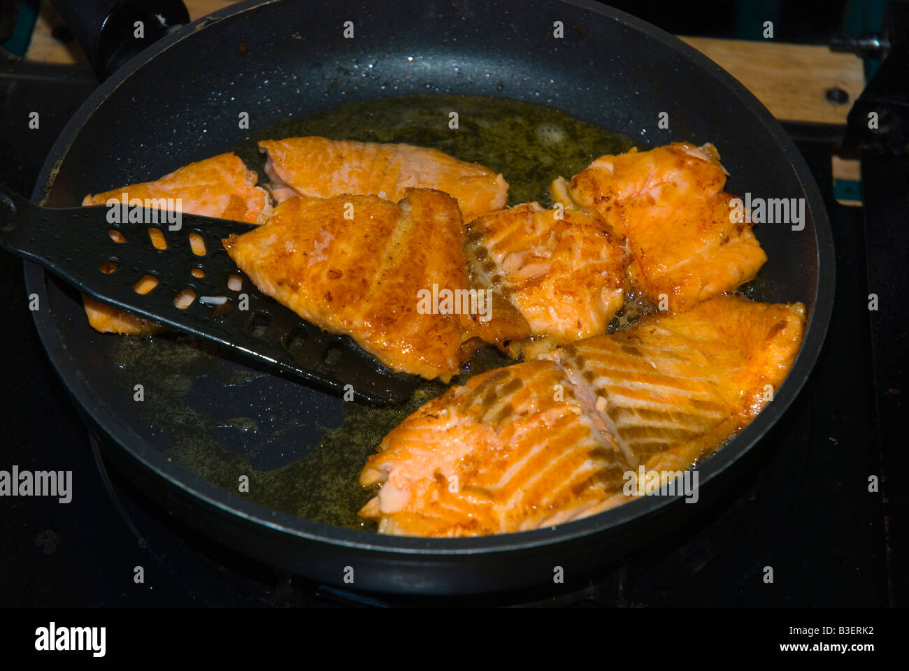 Salmon being fried on a pan Stock Photo - Alamy