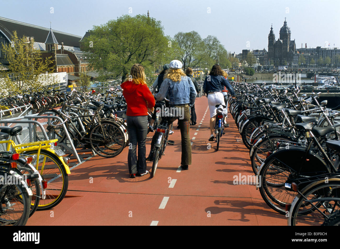 A young woman cycles down the ramp of a multi story bicycle park ...