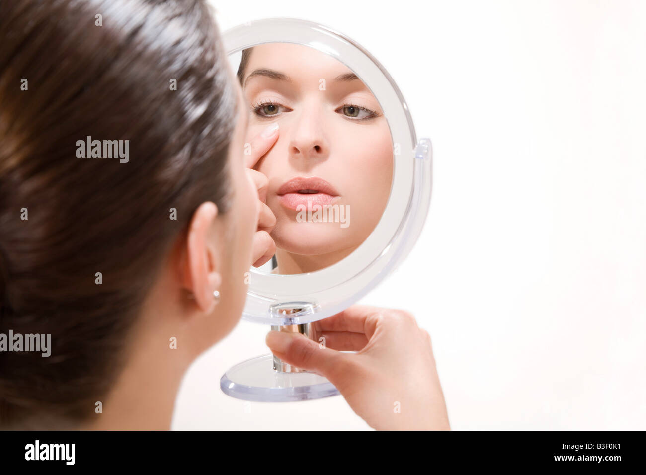 Young woman looking into mirror, portrait Stock Photo - Alamy