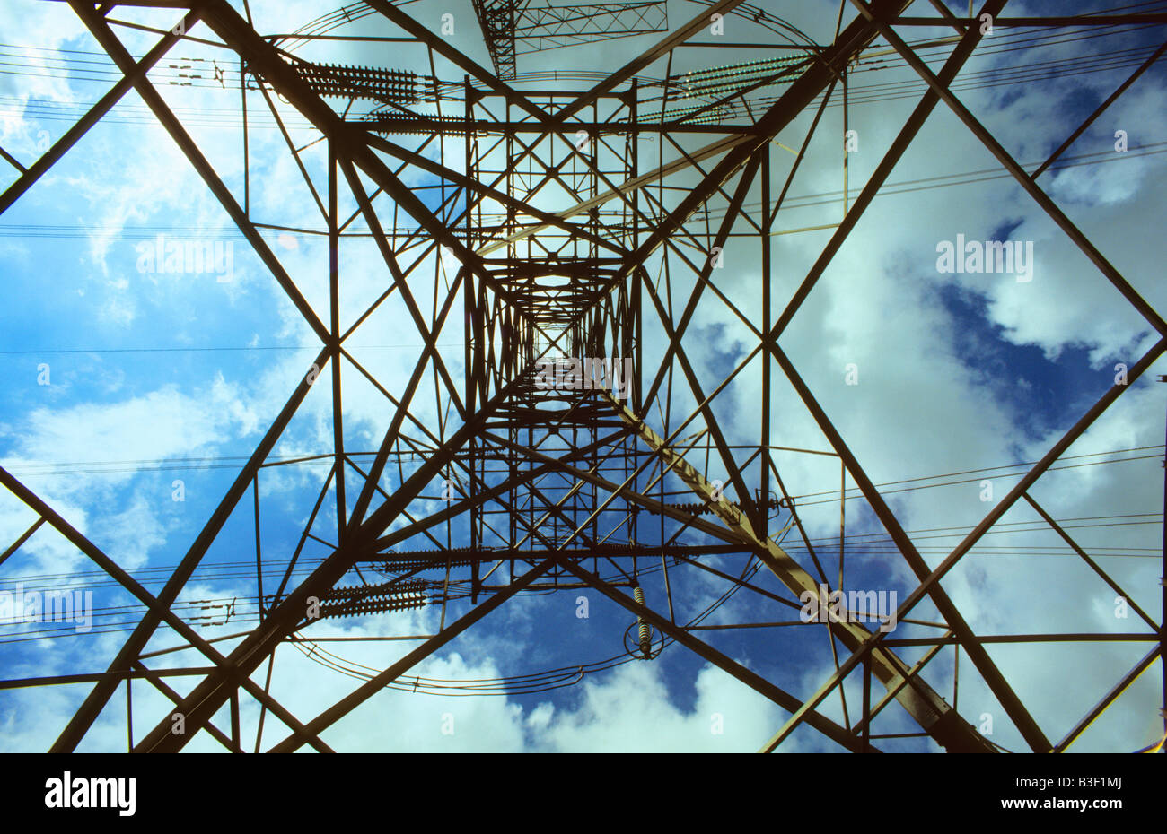 looking straight upwards at giant electricity pylon towering above at ...