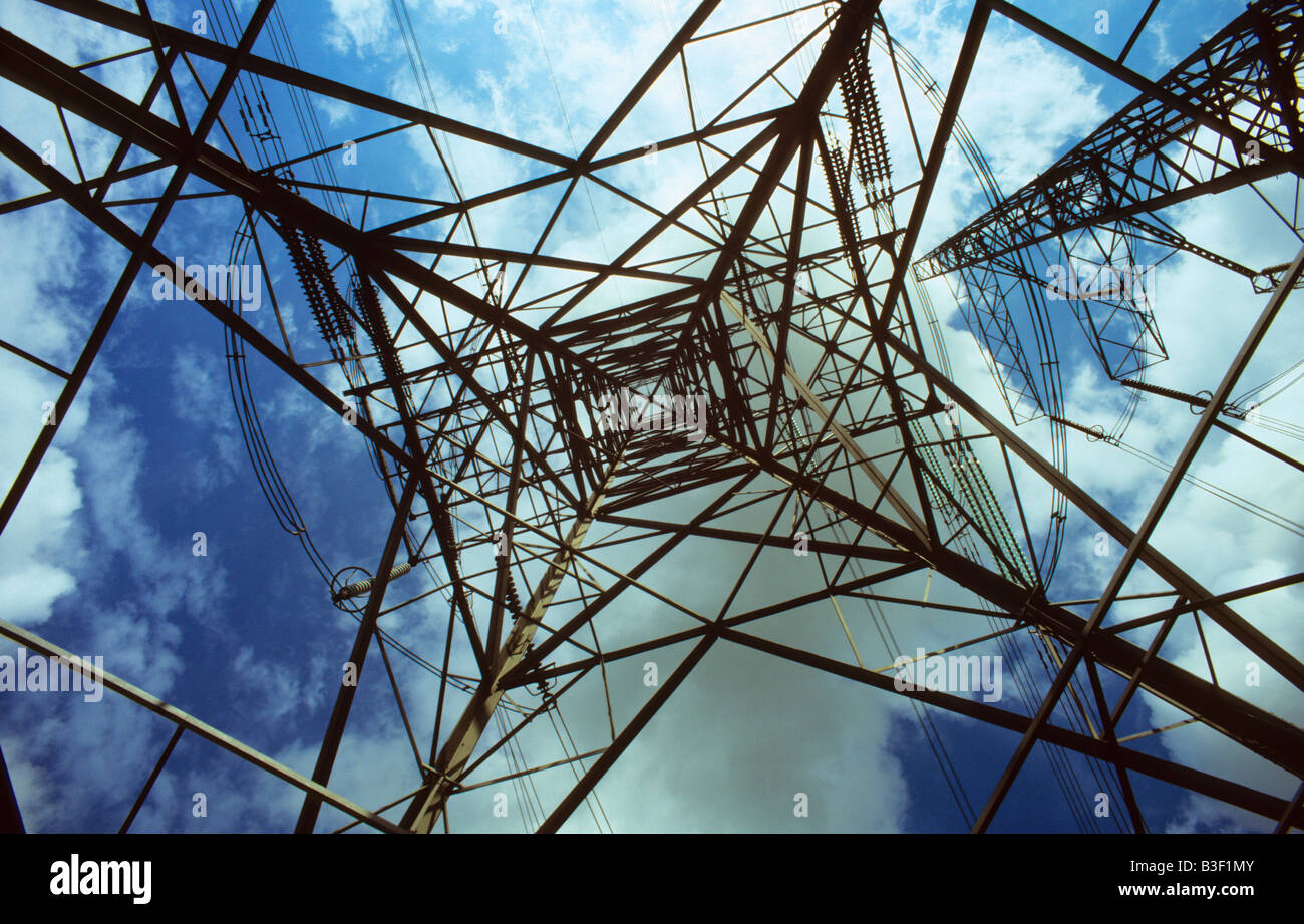 looking straight upwards at giant electricity pylon towering above at ...