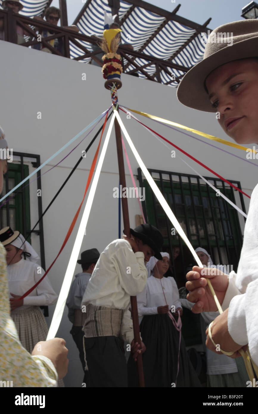 A group of children play a traditional game where they dance around a ...