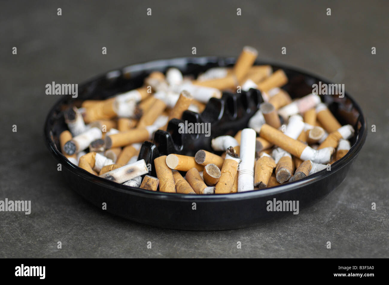 Full ashtray of cigarettes on table, close-up Stock Photo - Alamy
