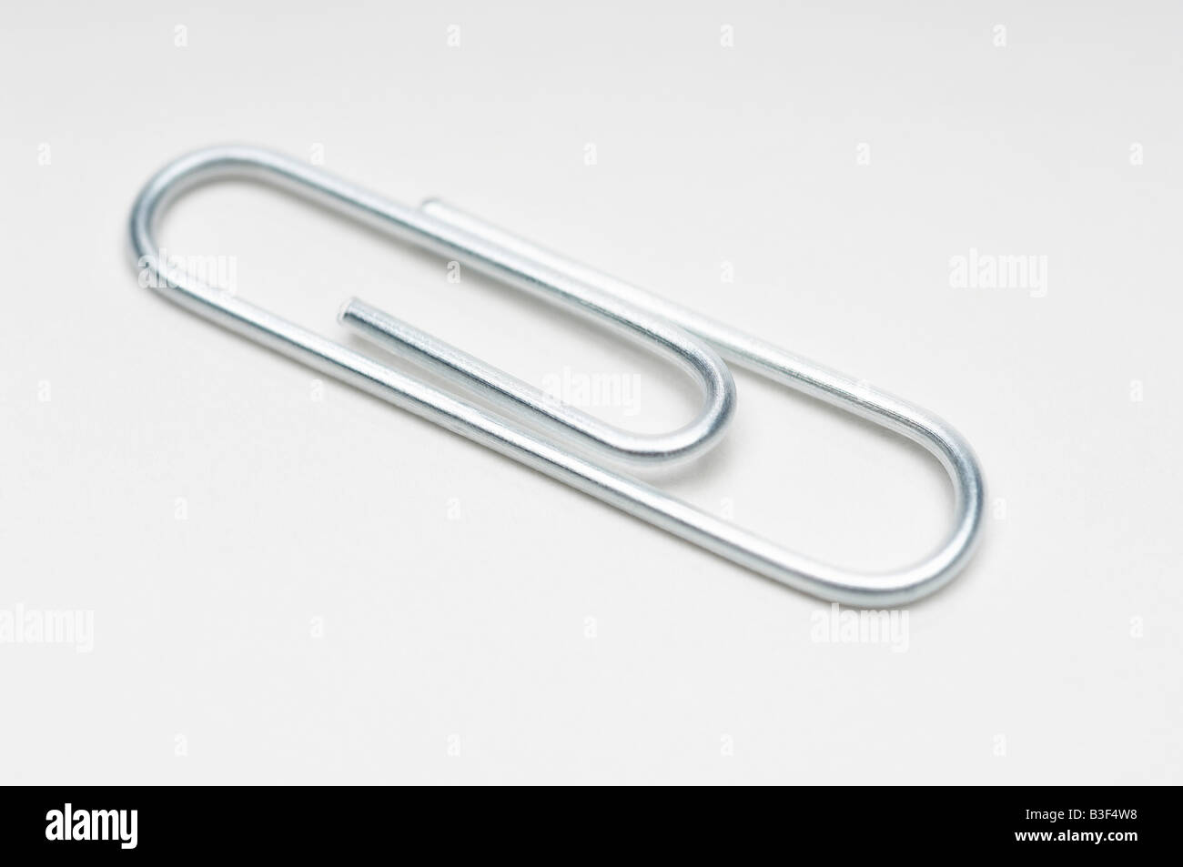 Silver paper clip on white background Stock Photo - Alamy