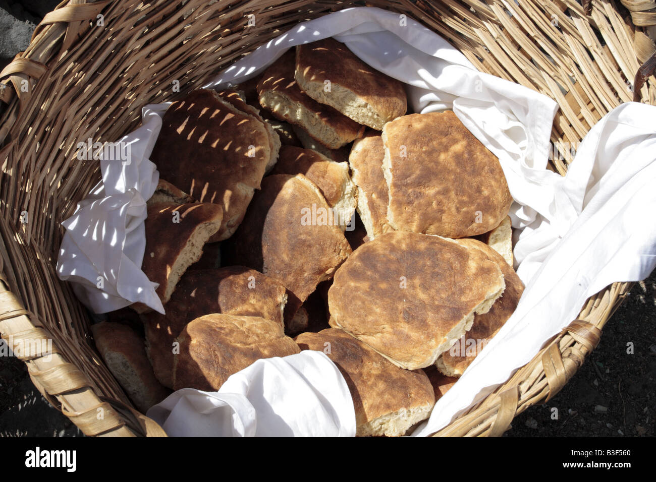 A basket of loaves of bread freshly baked in the communal bread oven at ...