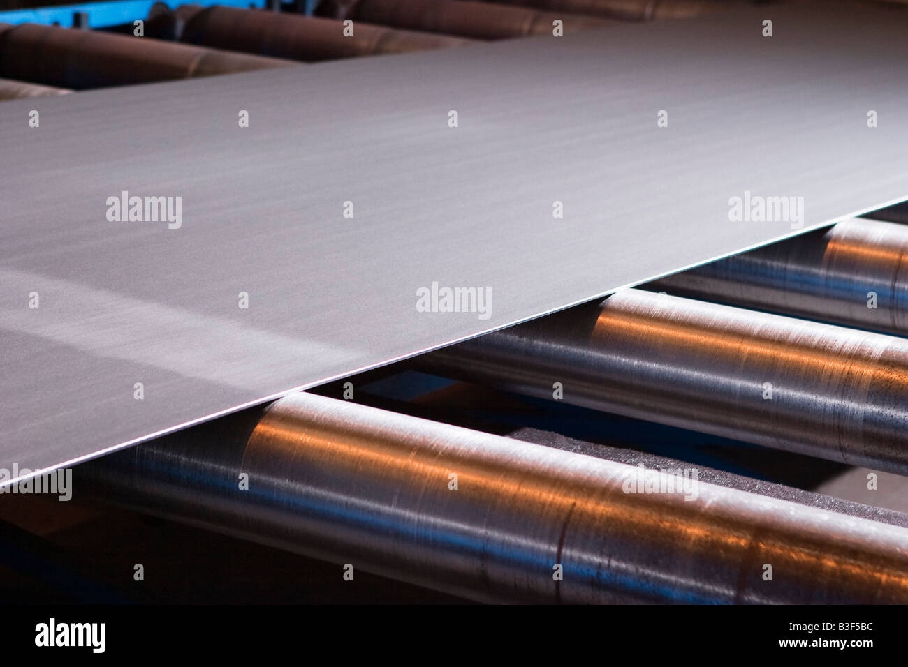 Continuous sheet of metallic material being fed through machine Stock ...