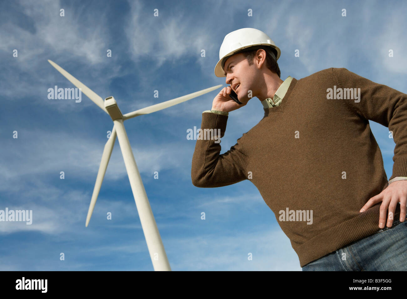 Engineer using mobile phone at wind farm Stock Photo - Alamy