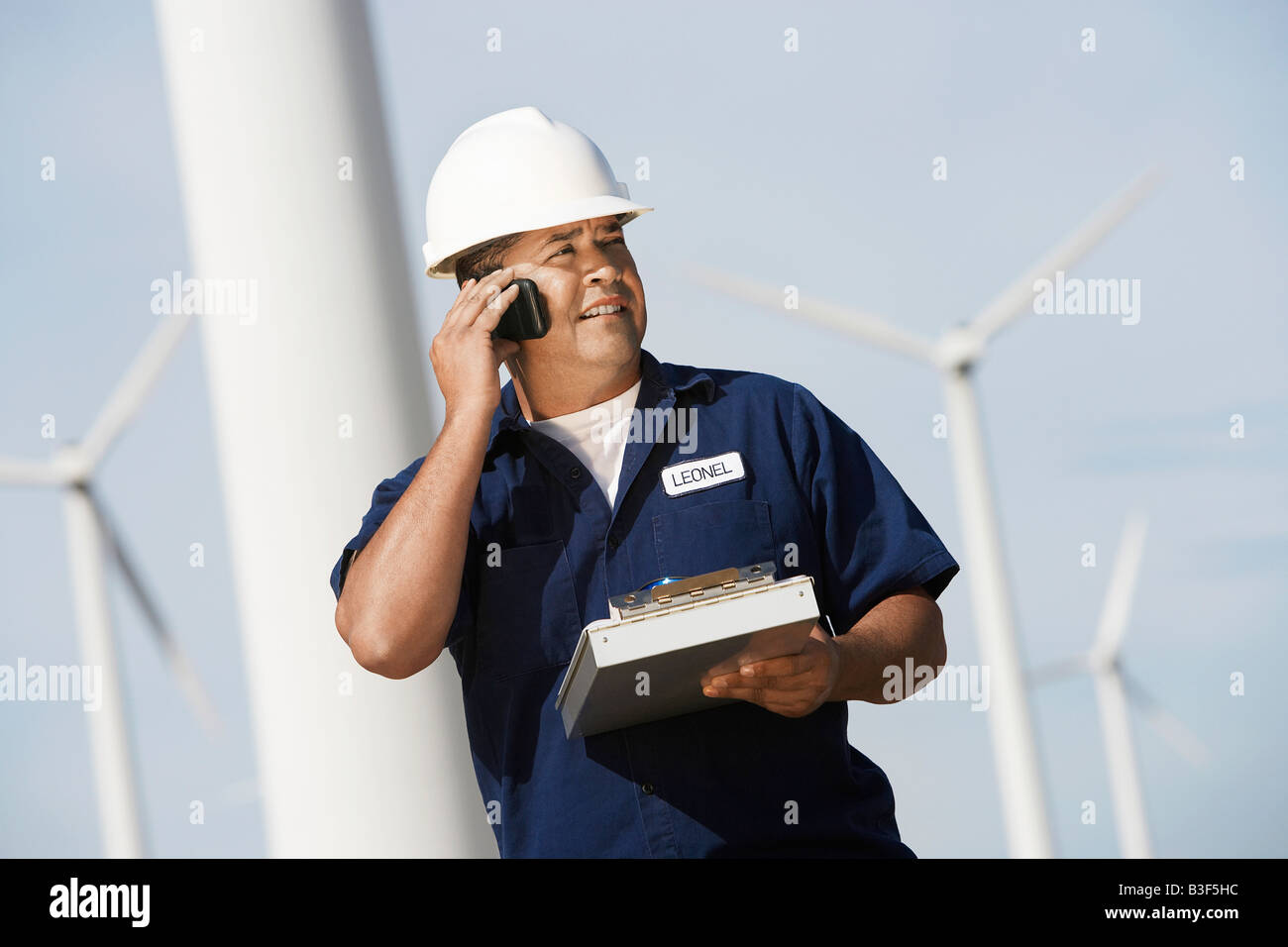 Engineer using mobile phone at wind farm Stock Photo - Alamy
