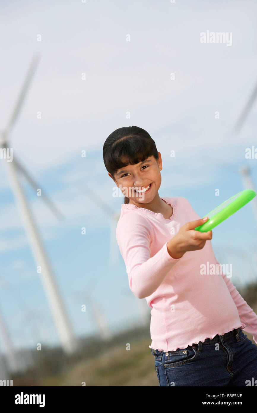 Girl (7-9) throwing disc at wind farm, portrait Stock Photo - Alamy