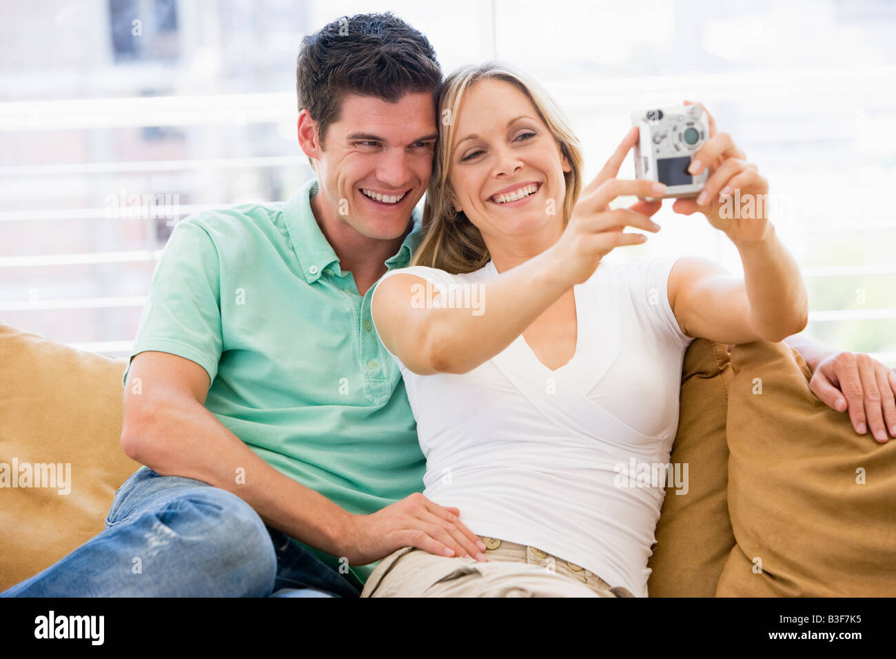 Couple in living room with digital camera smiling Stock Photo - Alamy
