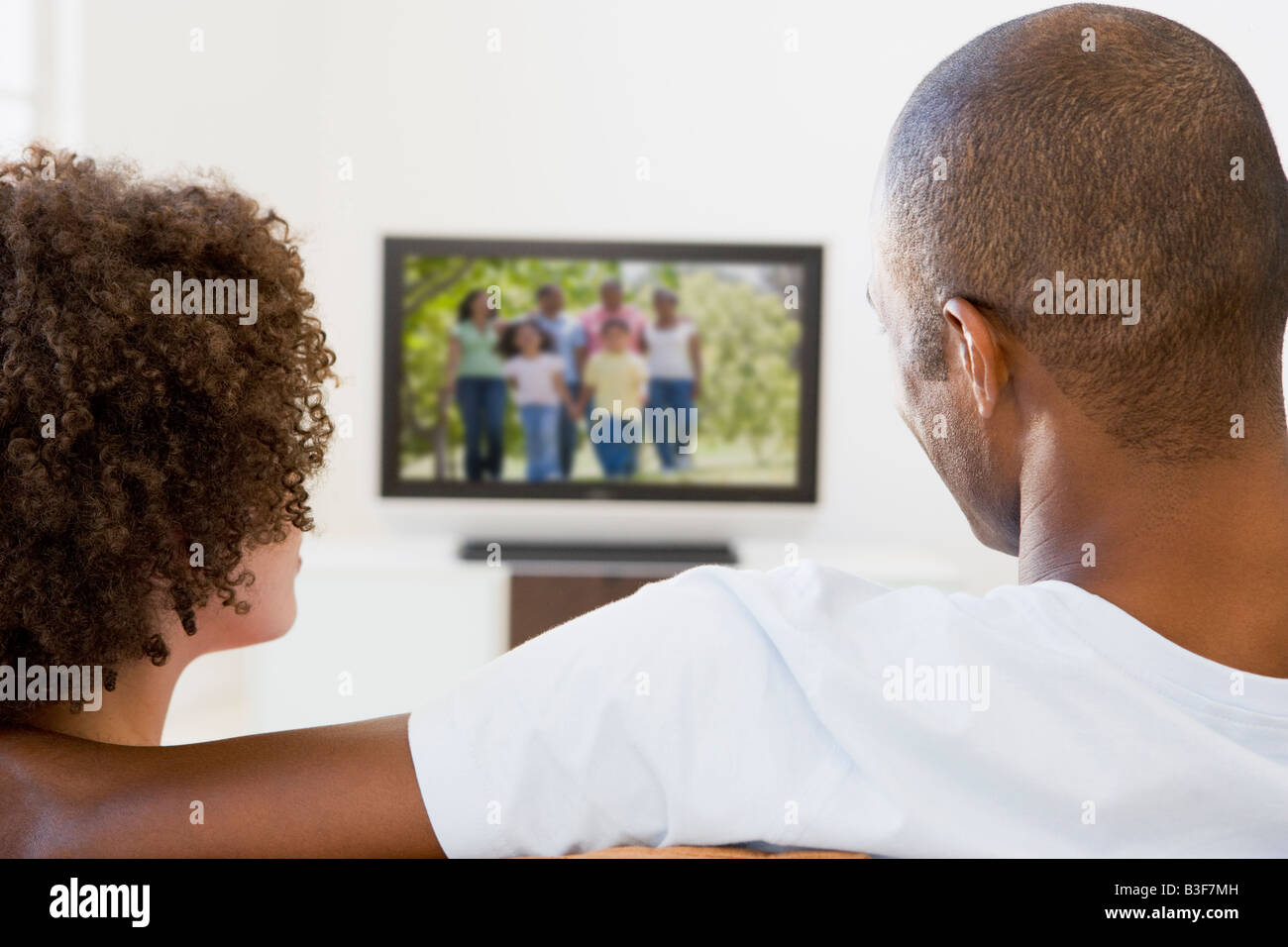 Couple in living room watching television Stock Photo - Alamy