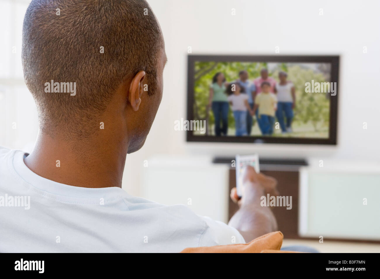 Man in living room watching television Stock Photo - Alamy