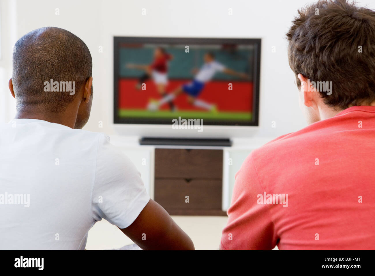 Two men in living room watching television Stock Photo - Alamy