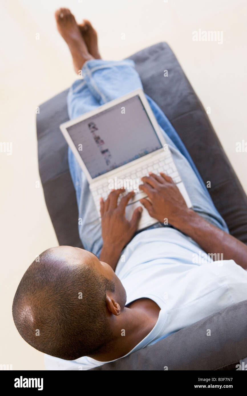 Man sitting in chair using laptop Stock Photo - Alamy