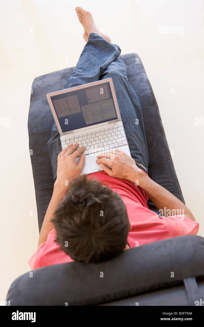 Man sitting in chair using laptop Stock Photo - Alamy