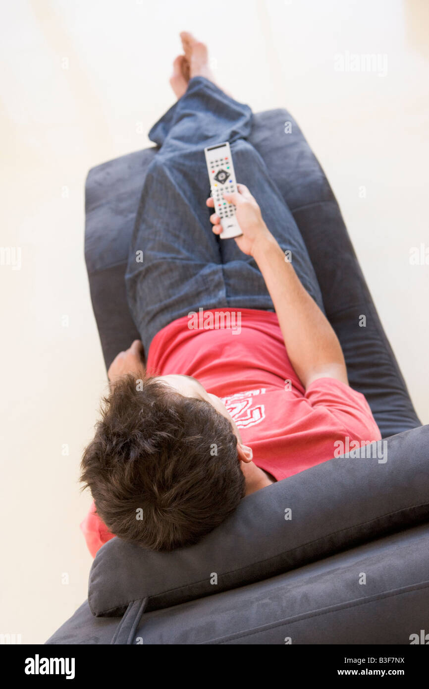 Man sitting in chair using remote control Stock Photo - Alamy