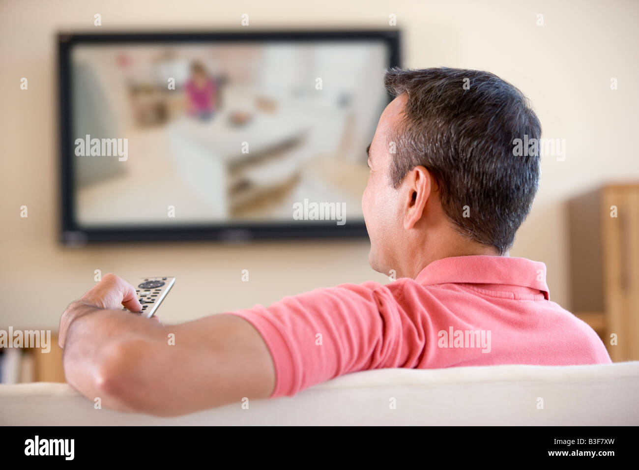 Man in living room watching television Stock Photo - Alamy
