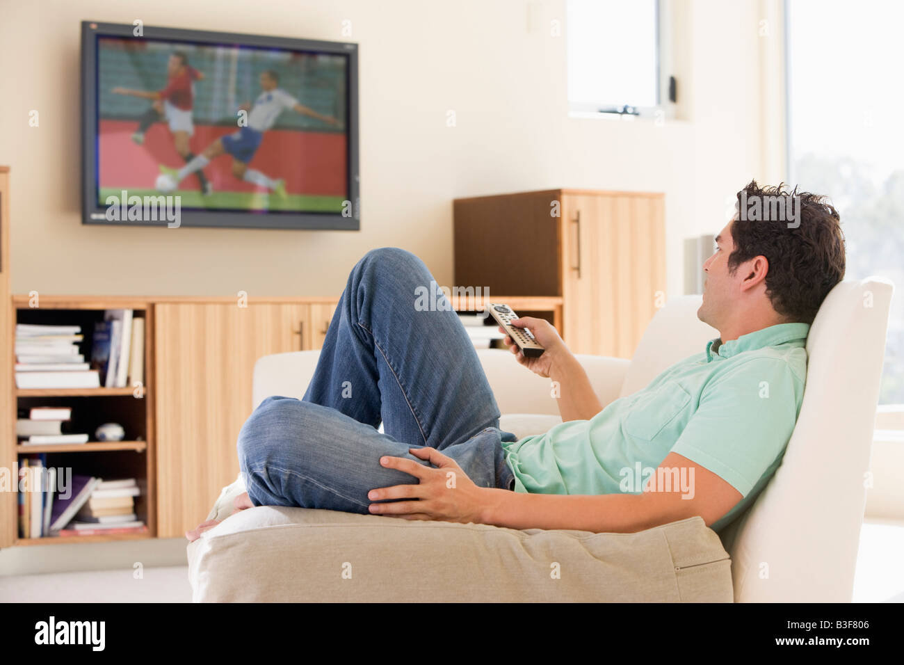 Man in living room watching television Stock Photo - Alamy
