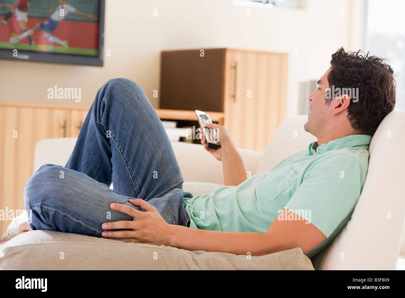 Man in living room watching television Stock Photo - Alamy
