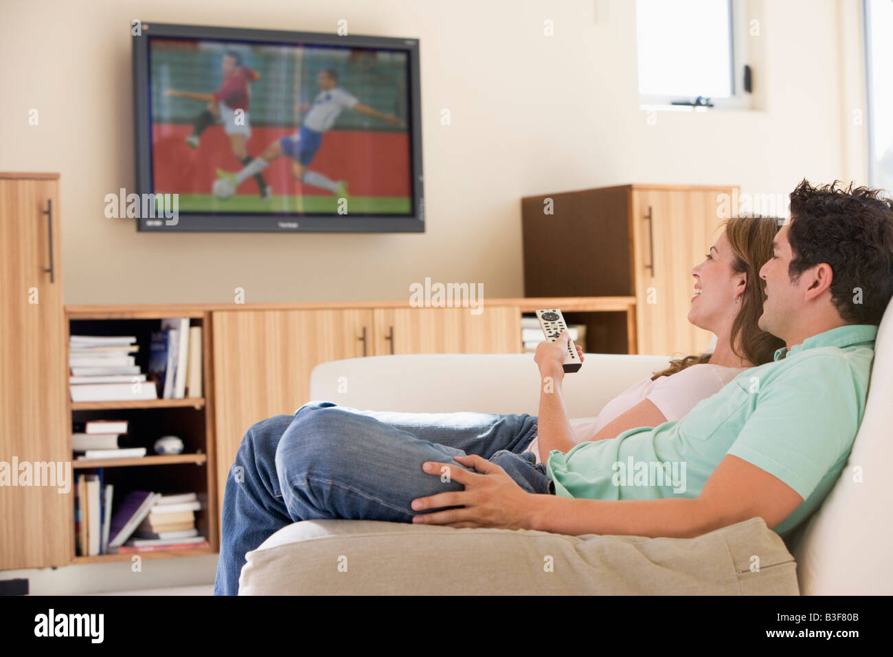 Couple in living room watching television Stock Photo - Alamy