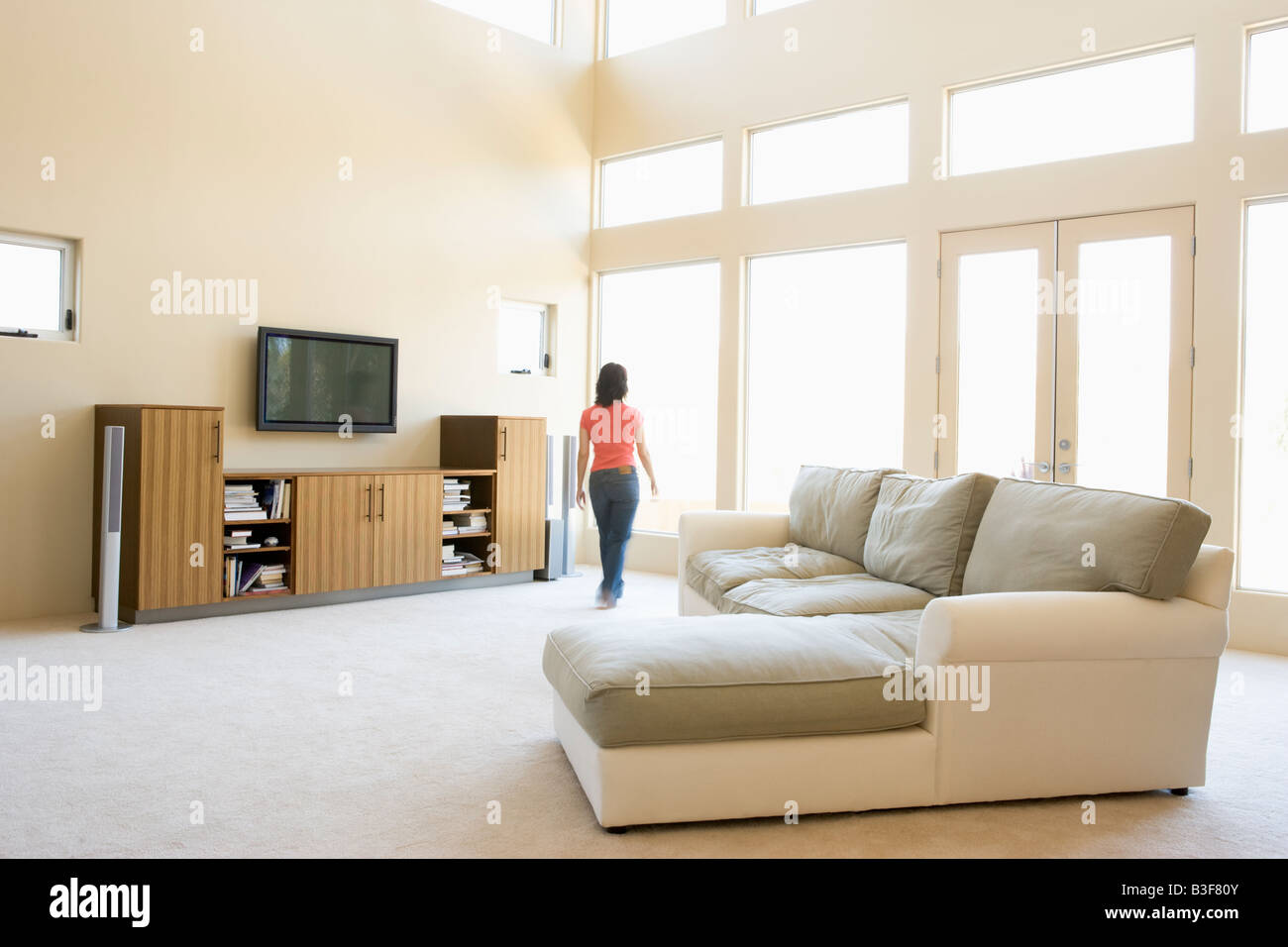 Woman walking through living room Stock Photo - Alamy