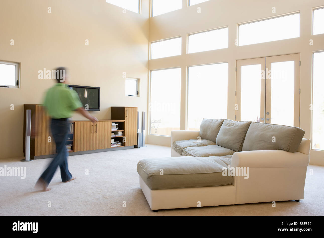 Man walking through living room Stock Photo - Alamy