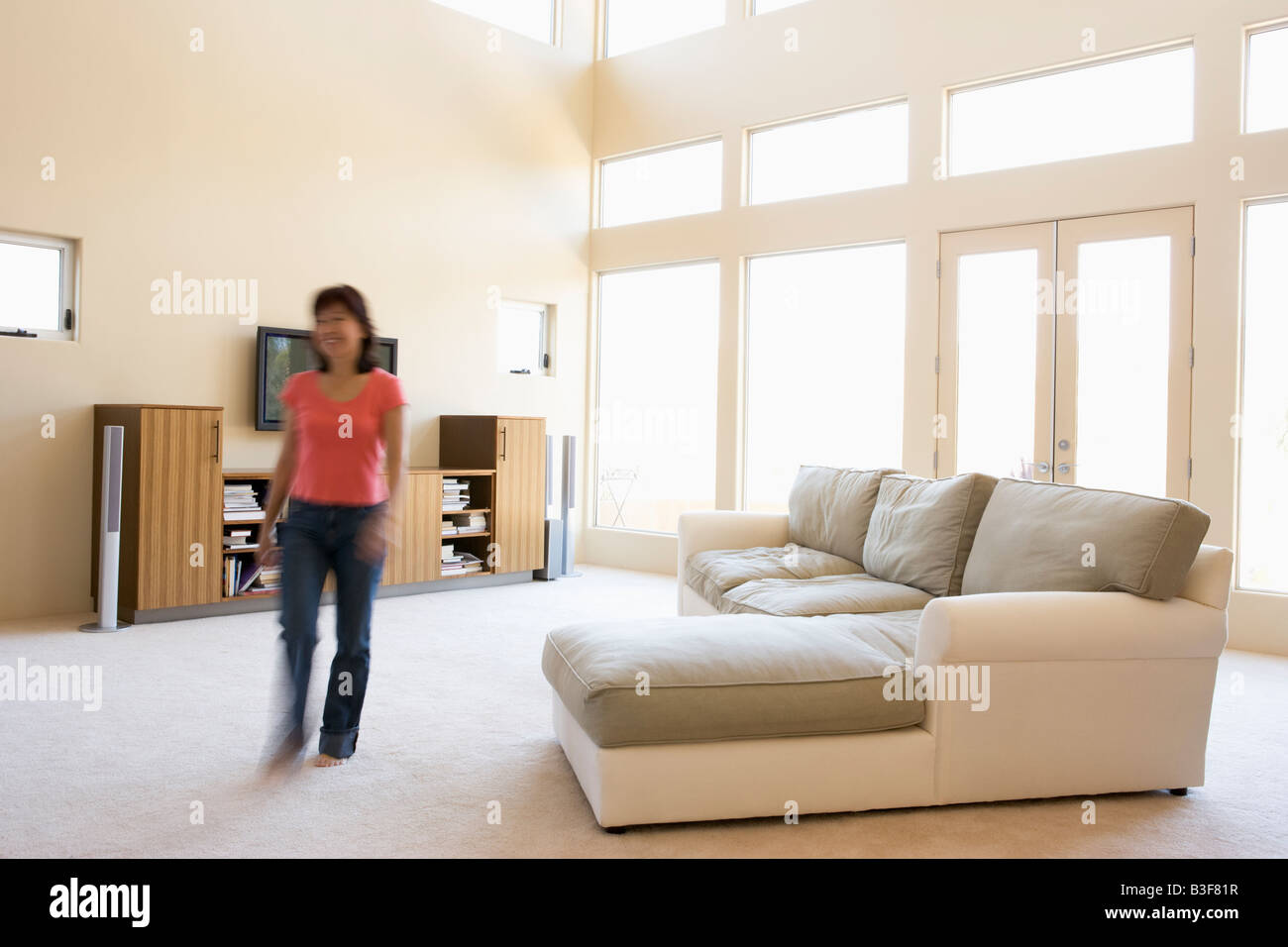 Woman walking through living room Stock Photo - Alamy