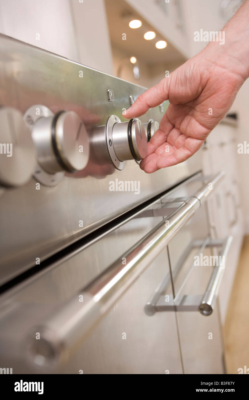Hand on stove dial in kitchen Stock Photo - Alamy
