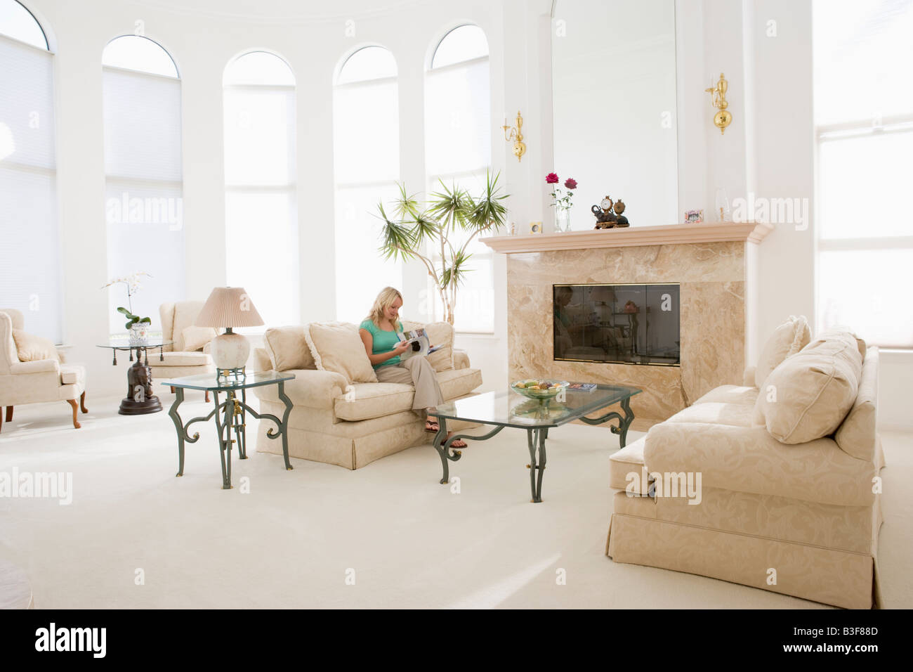 Woman reading magazine in living room Stock Photo - Alamy