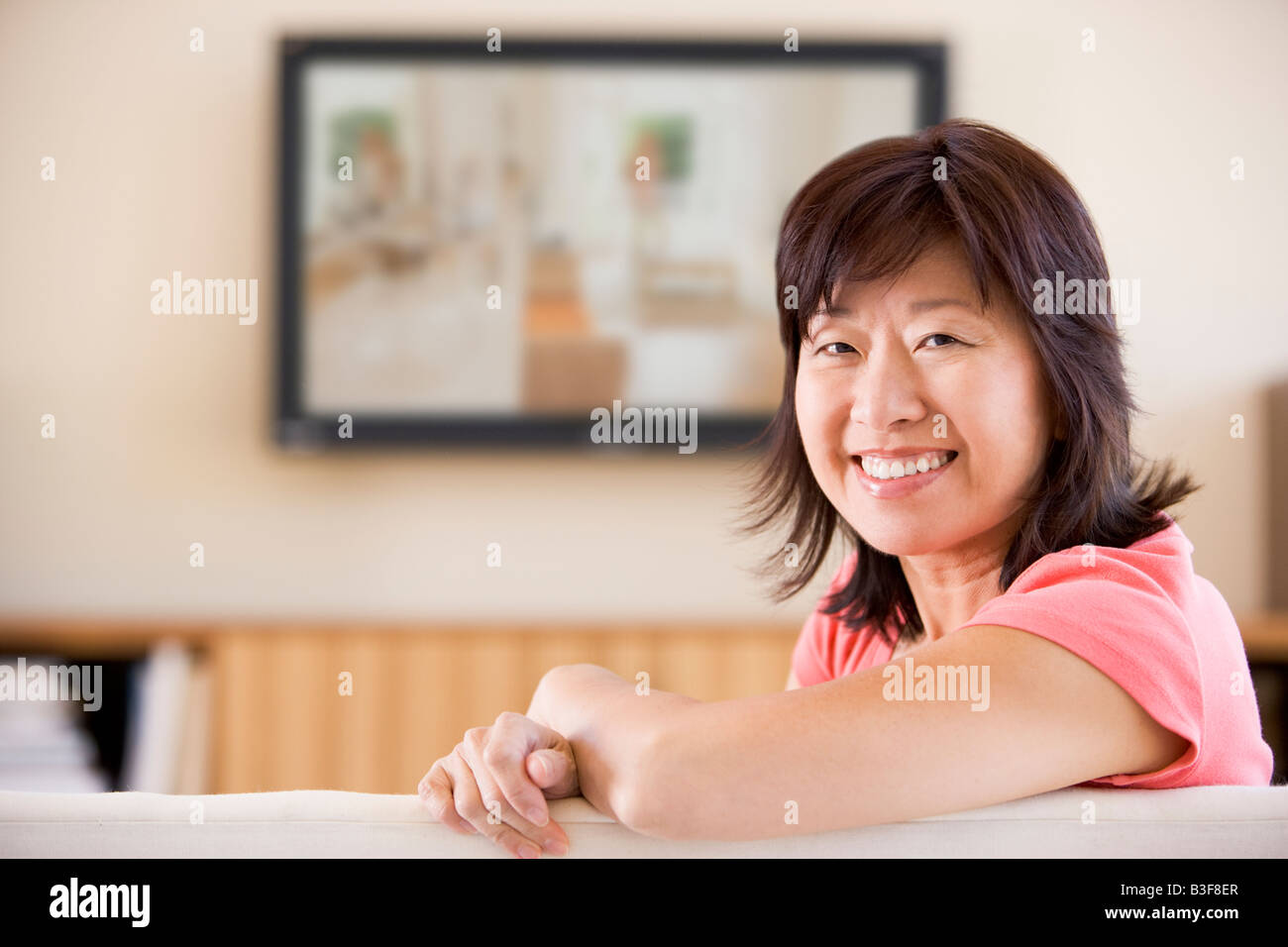 Woman watching television smiling Stock Photo - Alamy