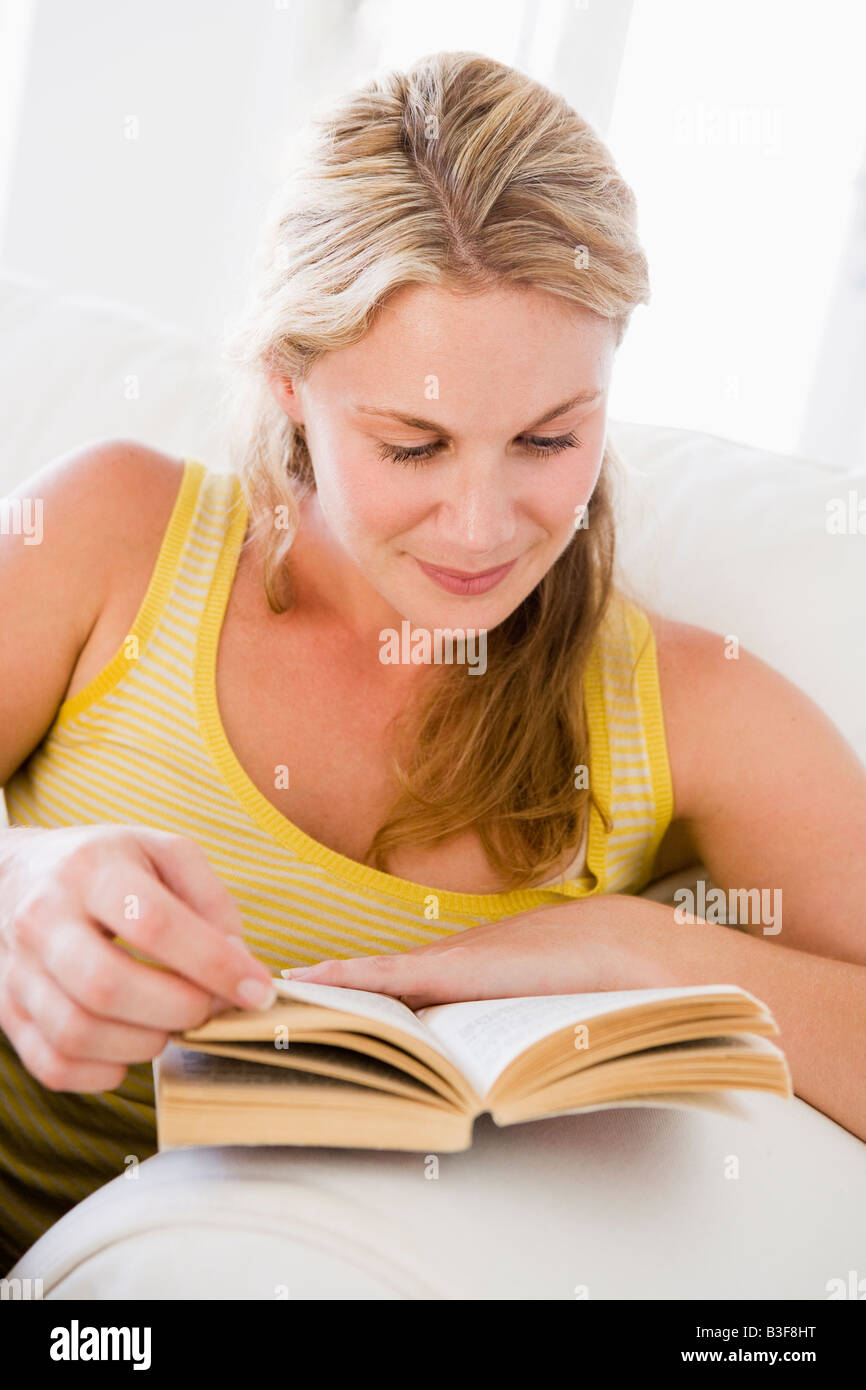 Woman in living room reading book Stock Photo - Alamy