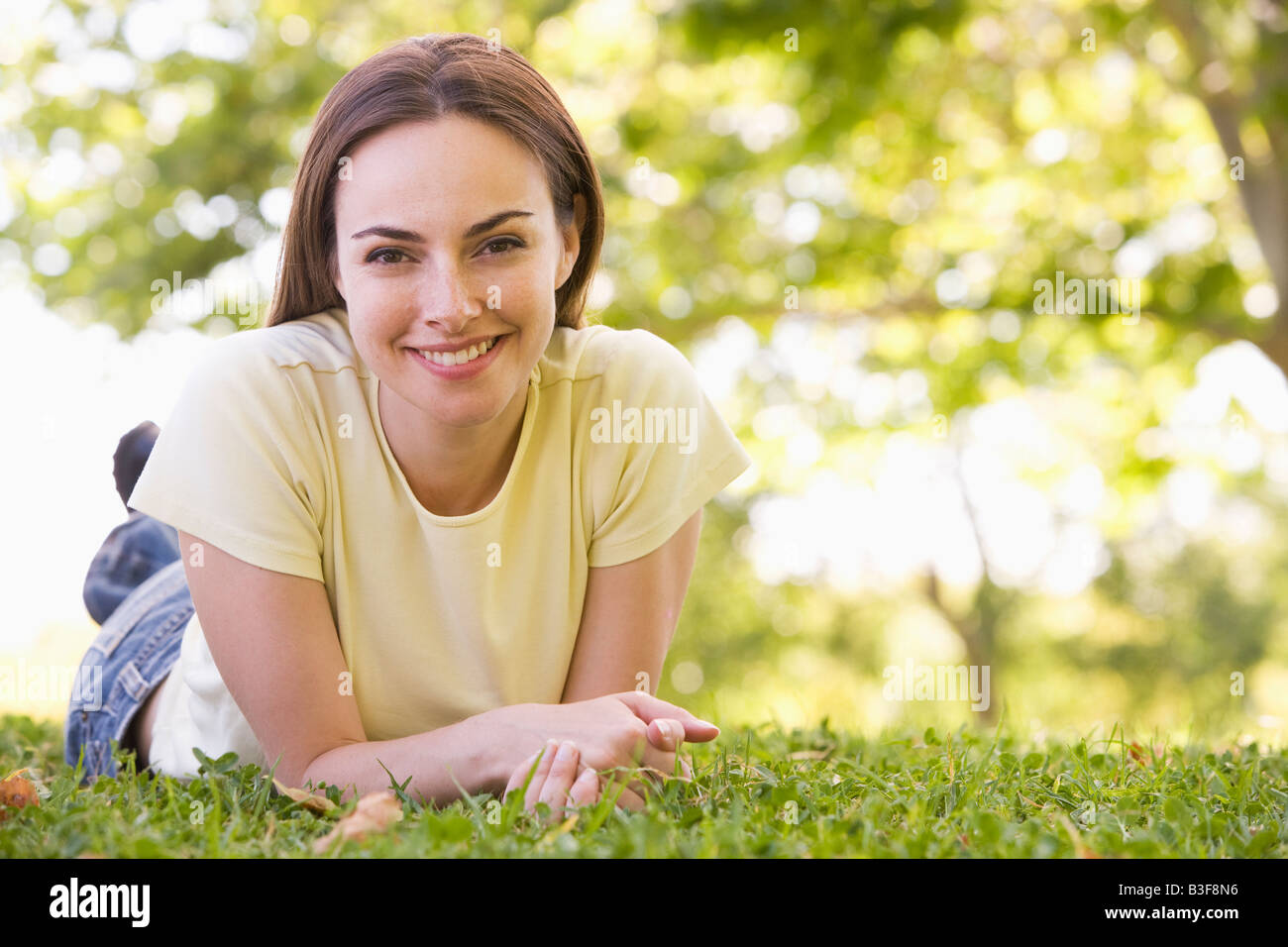 Woman lying outdoors smiling Stock Photo - Alamy