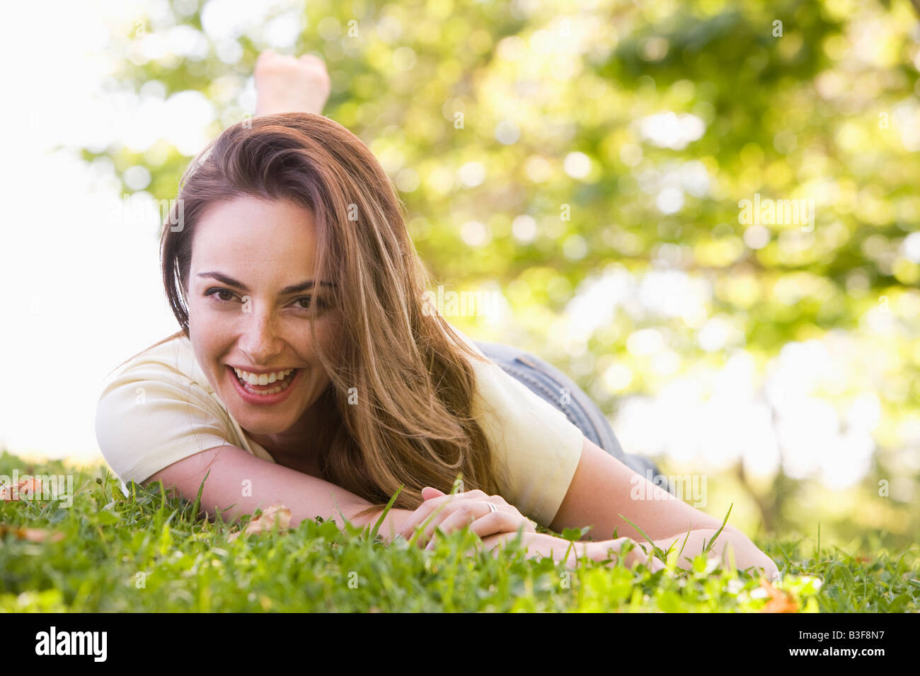 Woman lying outdoors smiling Stock Photo - Alamy