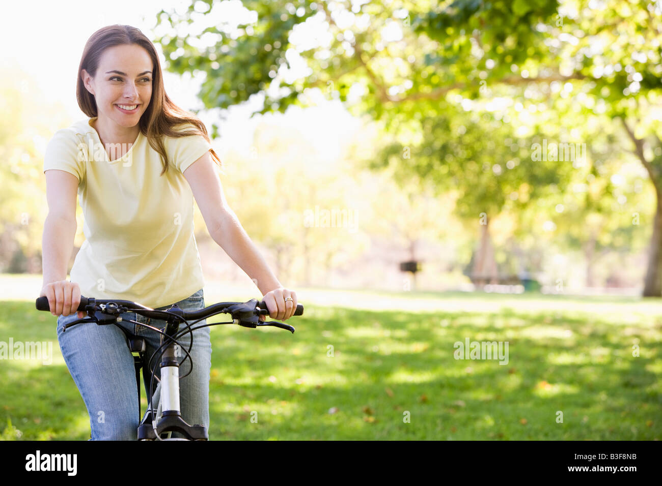 Woman on bicycle smiling Stock Photo - Alamy