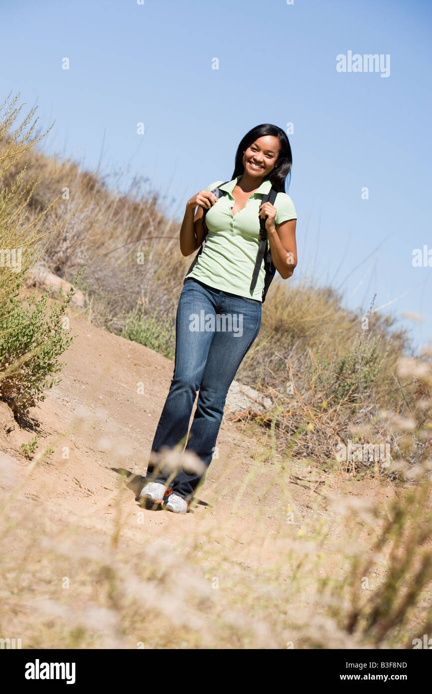 Woman walking on beach path smiling Stock Photo - Alamy